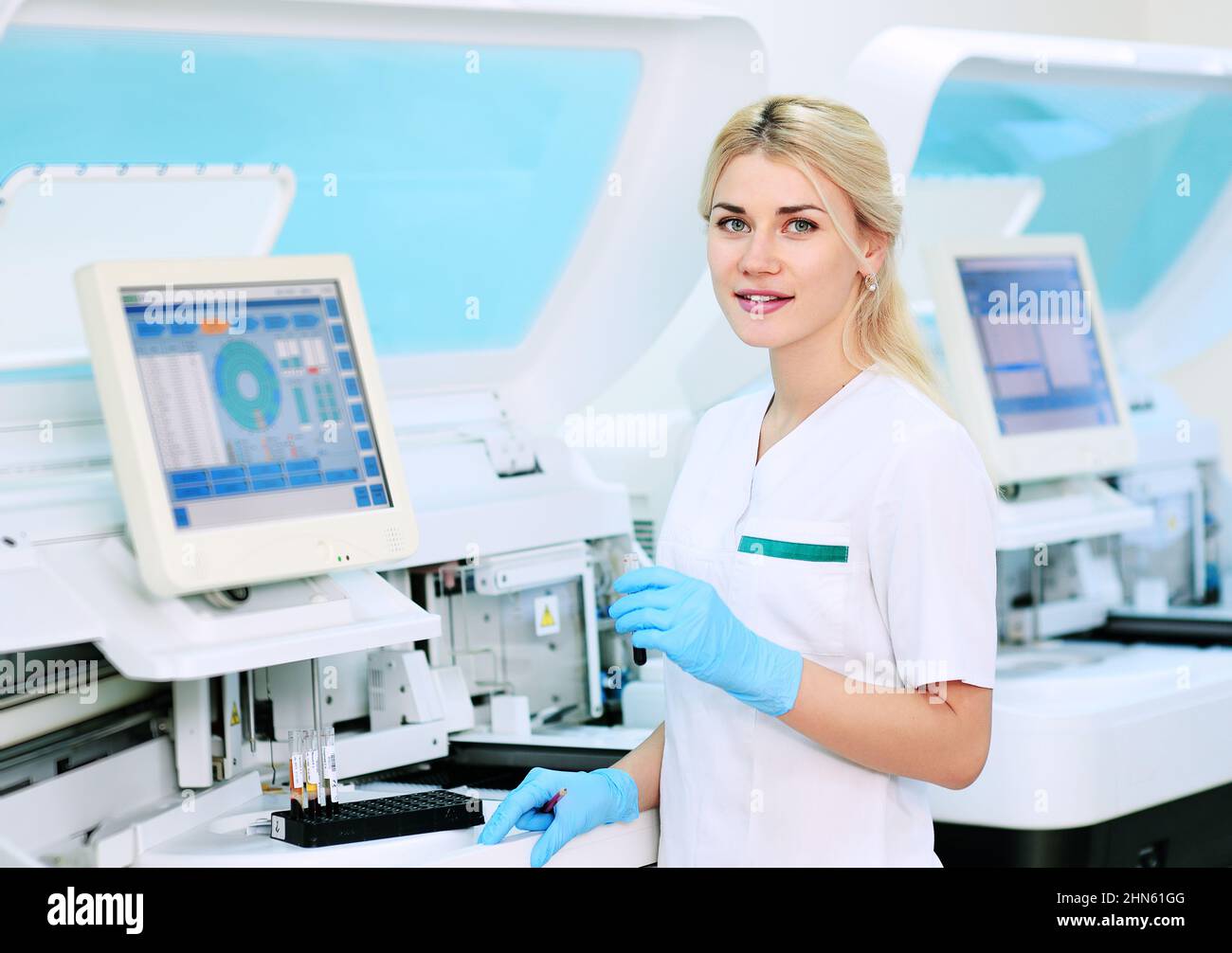 scientist in a laboratory places test tubes with blood or urine in the ...
