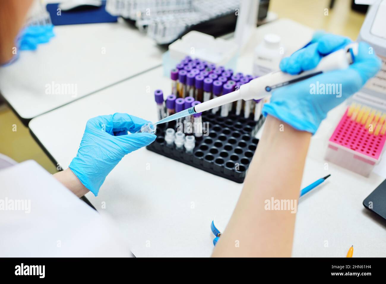 scientist in a medical laboratory with a dispenser in his hands is ...