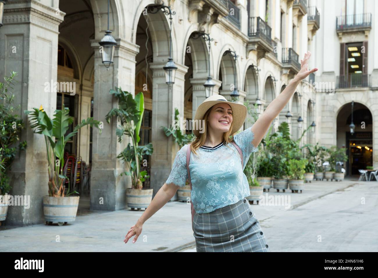 Emotional female in hat glad posing and holding arms to sideward-upward ...