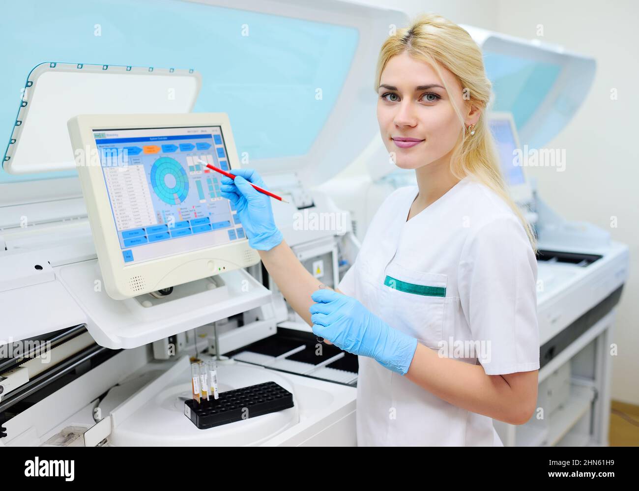 scientist in a laboratory places test tubes with blood or urine in the ...