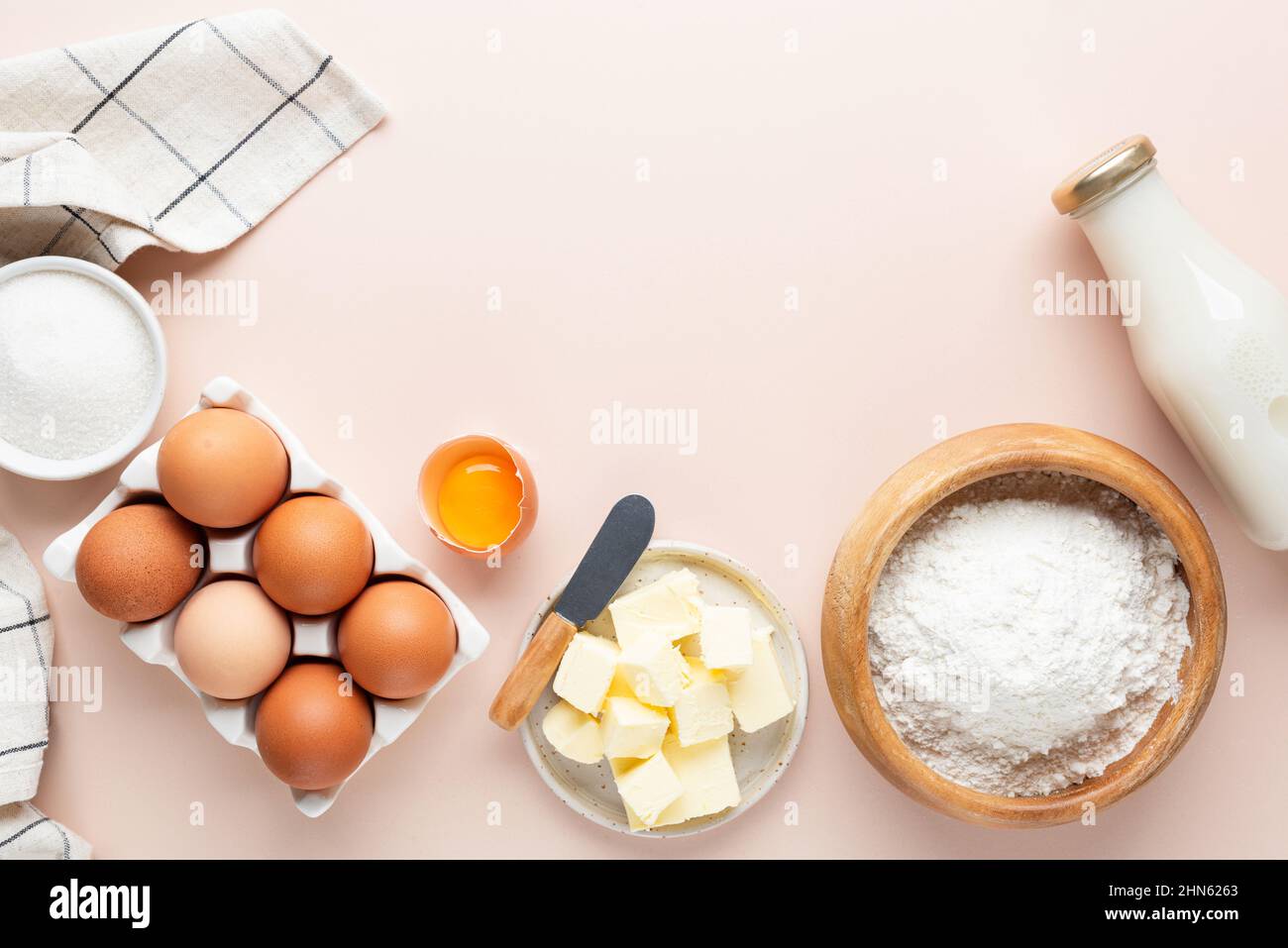 Baking ingredients on beige background. Flour eggs butter sugar and oat ...