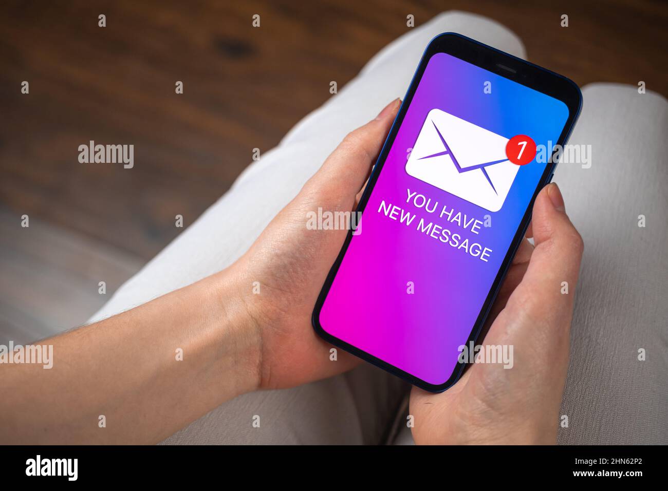 Hands holding smartphone with new message concept on screen. New e-mail ...