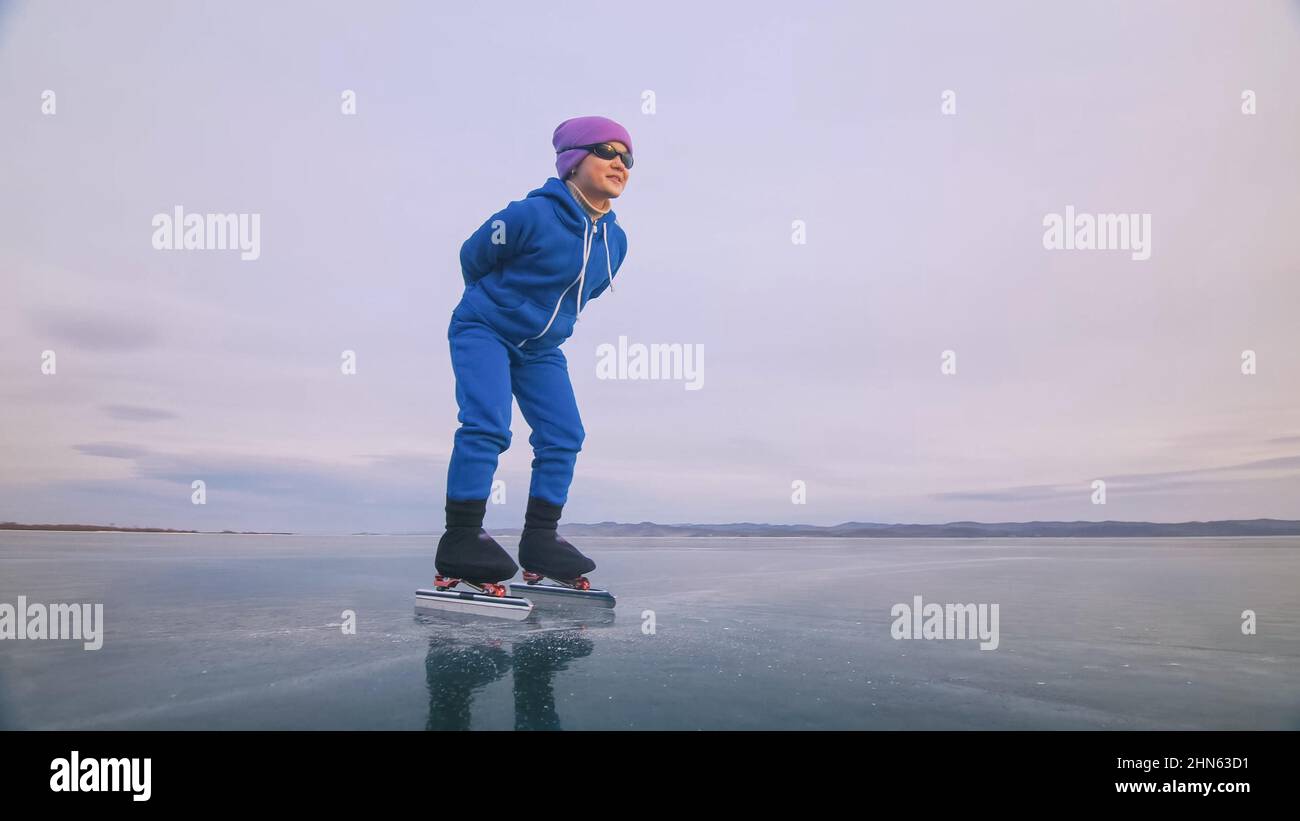 The child train on ice speed skating. The athlete at the start, in a ...