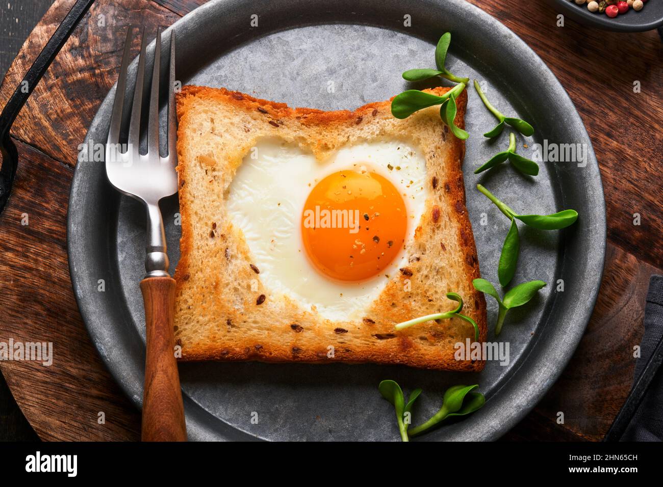 Valentines day breakfast. Fried eggs and bread in the shape of a heart and fresh vegetables on ...
