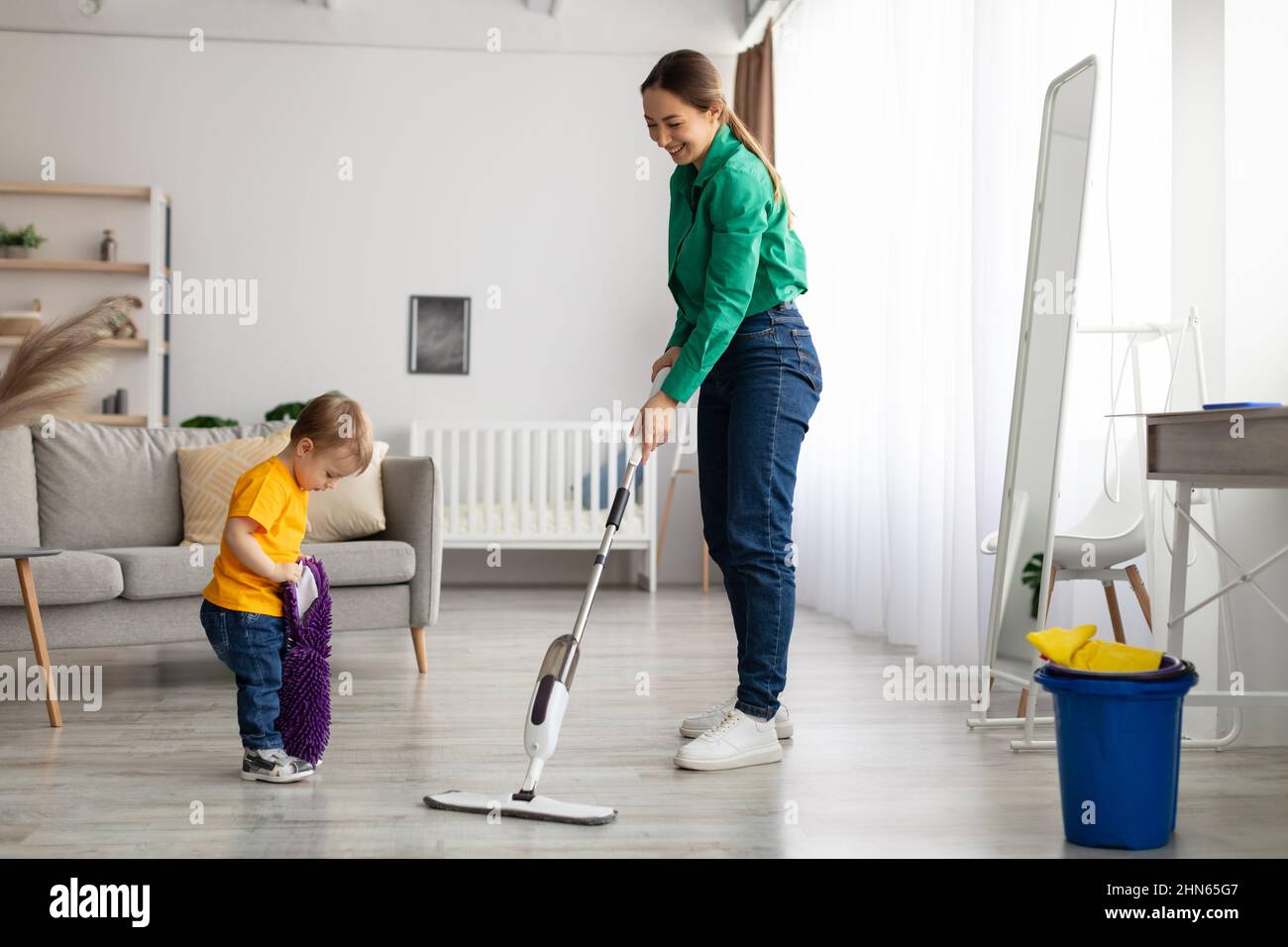 Helping hand. Little toddler boy helping mother doing the cleaning, mom ...