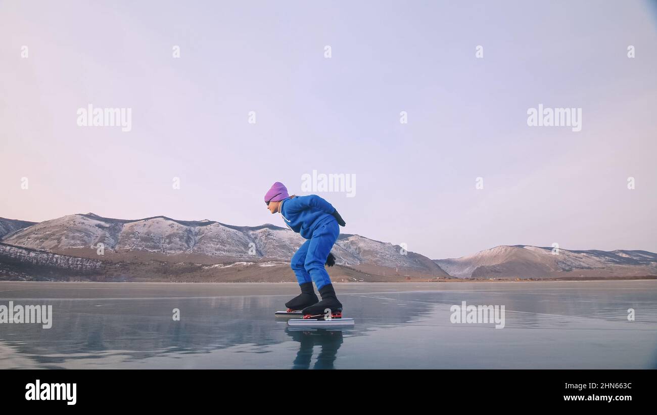 The child train on ice professional speed skating. The girl skates in ...