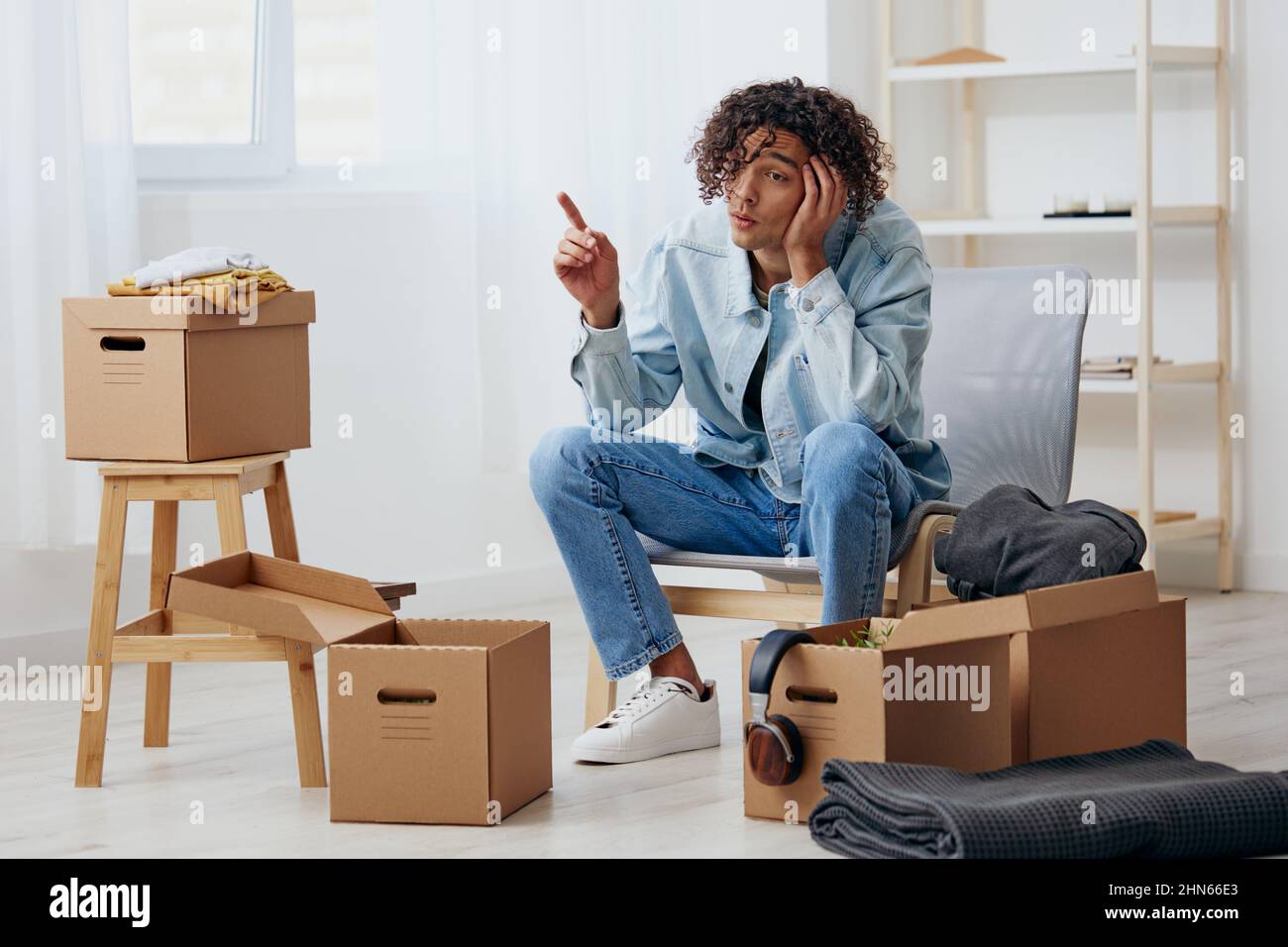 A young man unpacking things from boxes in the room interior Stock ...