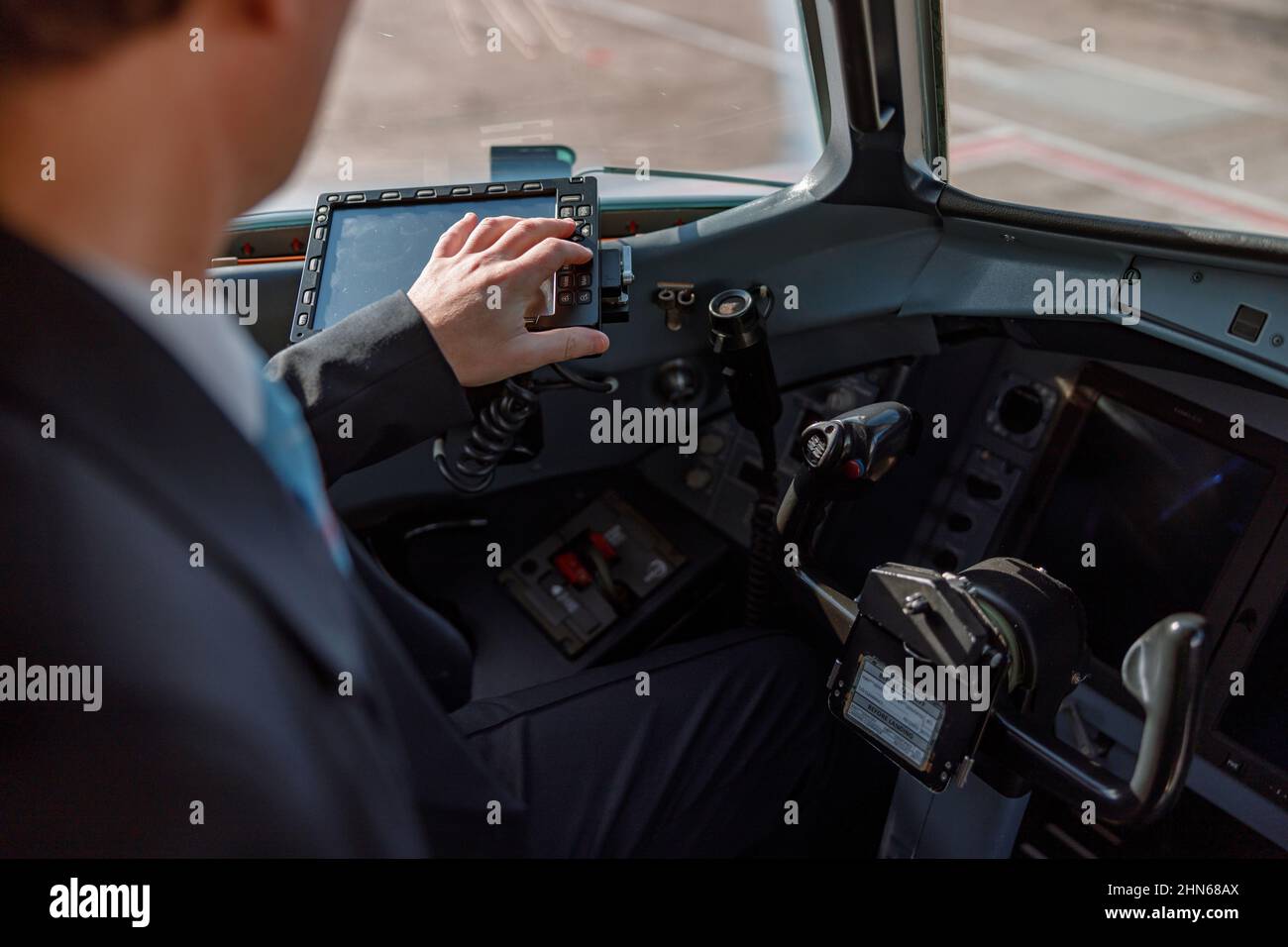Aircraft pilot sitting in cockpit and using flight display Stock Photo ...