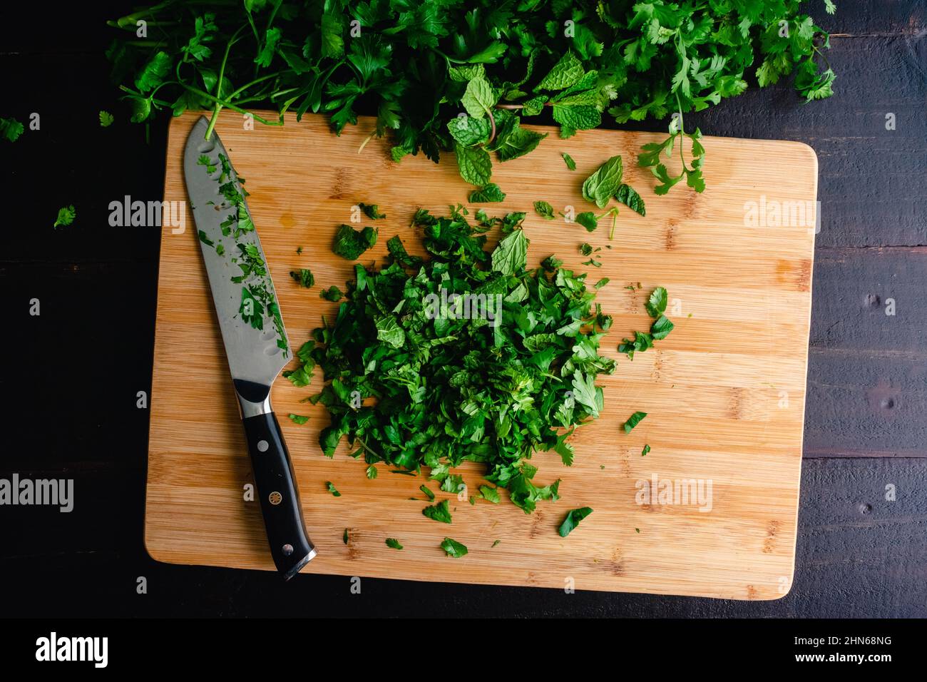 Chopped Fresh Herbs on a Bamboo Cutting Board: A pile of chopped mint ...