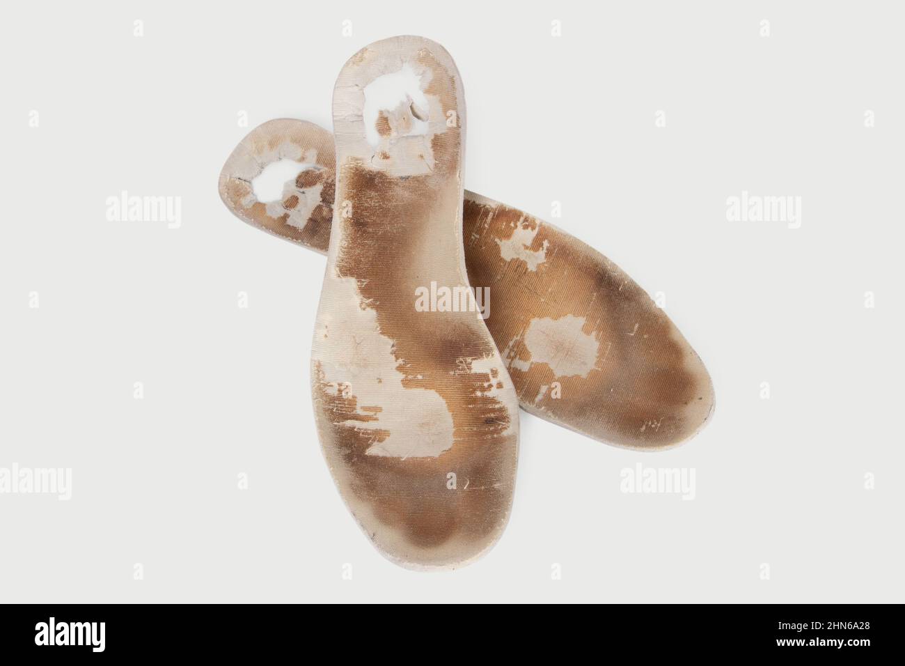 Two old, shabby orthopedic insoles isolated on white background. Dirty ...