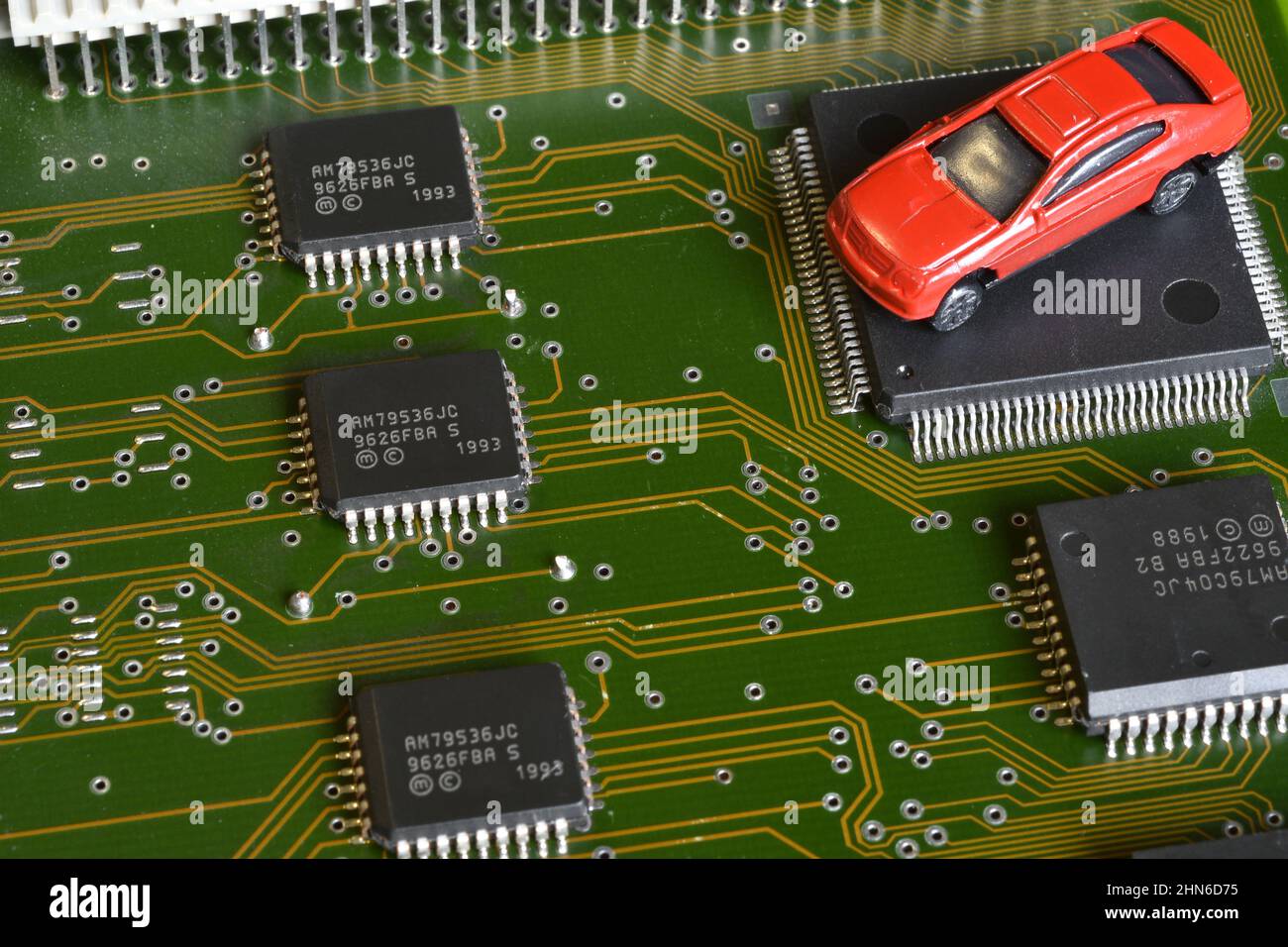 Toy cars on electronic board and microchip. The shortage of microchips ...