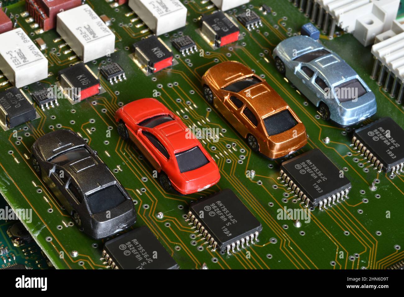 Toy cars on electronic board and microchip. The shortage of microchips ...