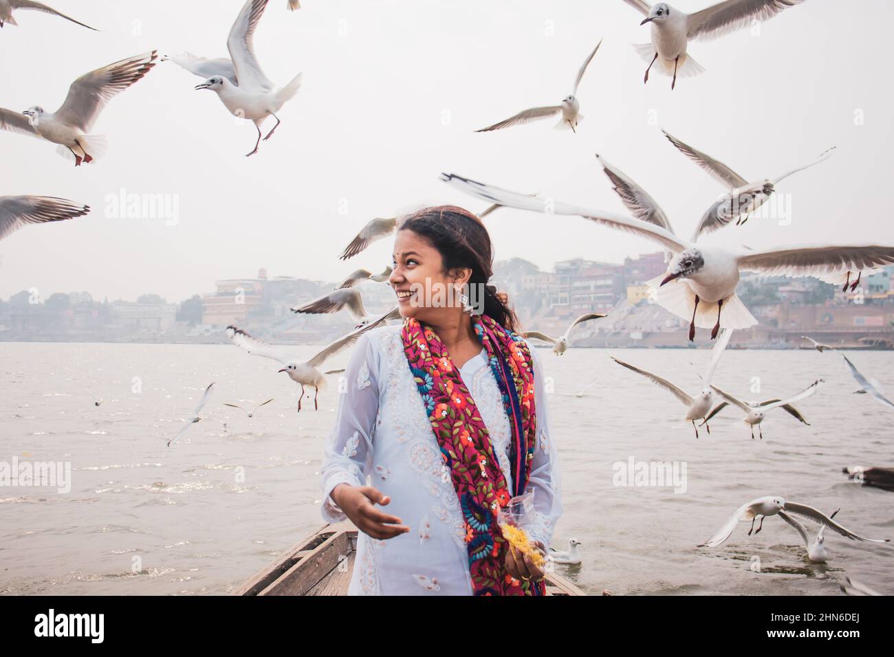 Girl posing in Varanasi surrounding by birds Stock Photo - Alamy