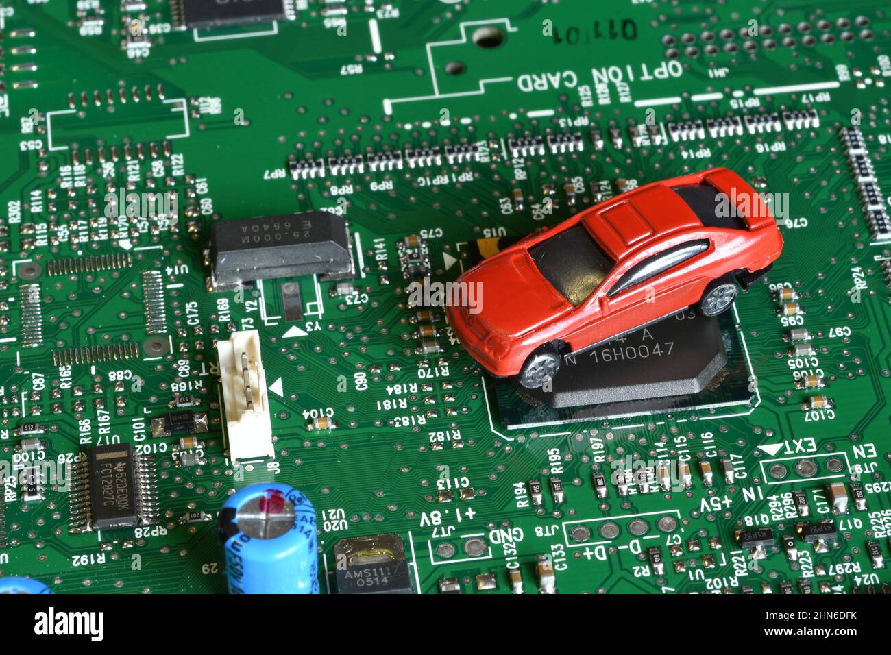 Toy cars on electronic board and microchip. The shortage of microchips ...