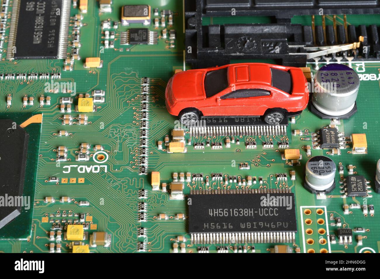 Toy cars on electronic board and microchip. The shortage of microchips ...