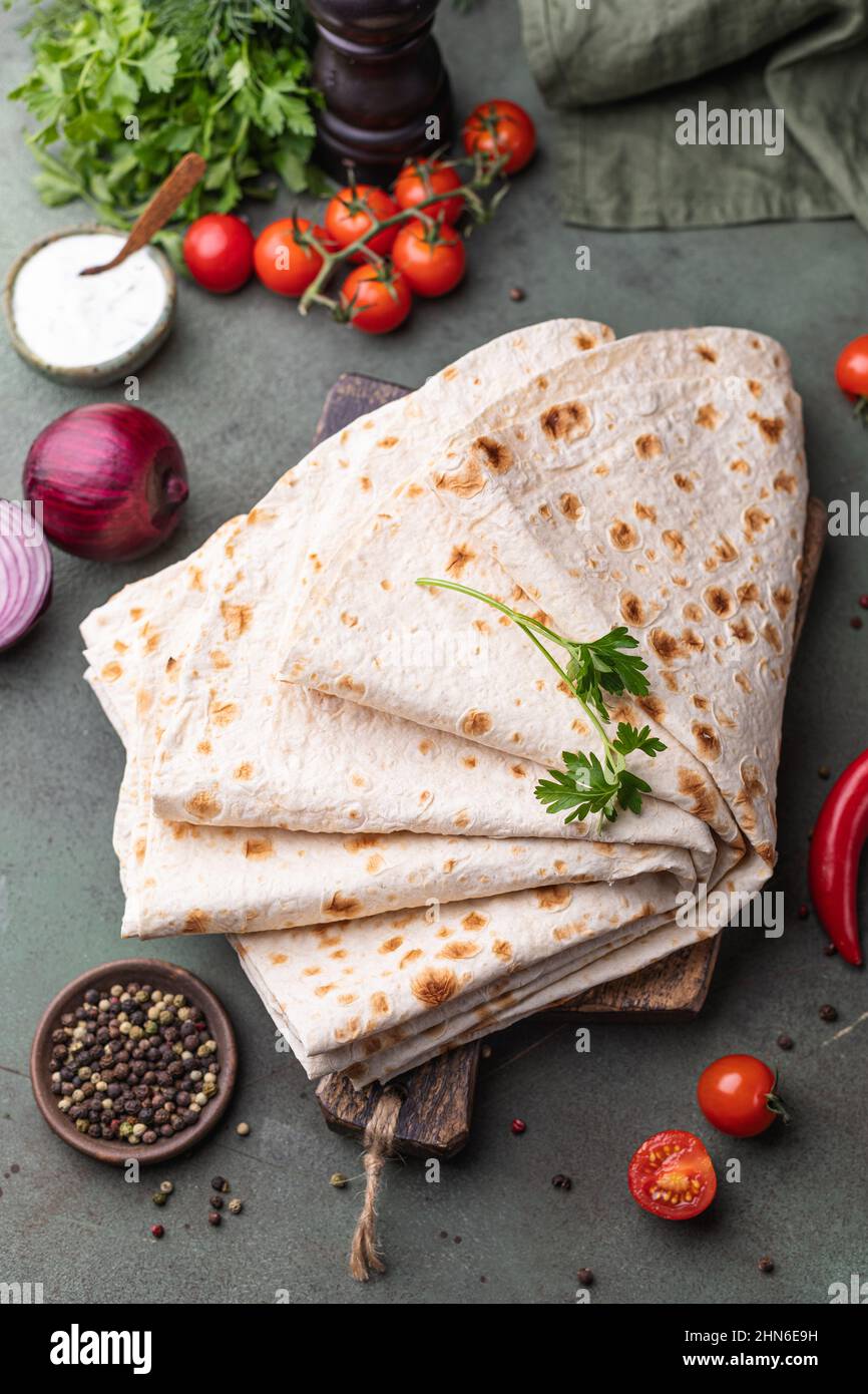 Lavash rolled on a wooden board, thin traditional oriental bread ...
