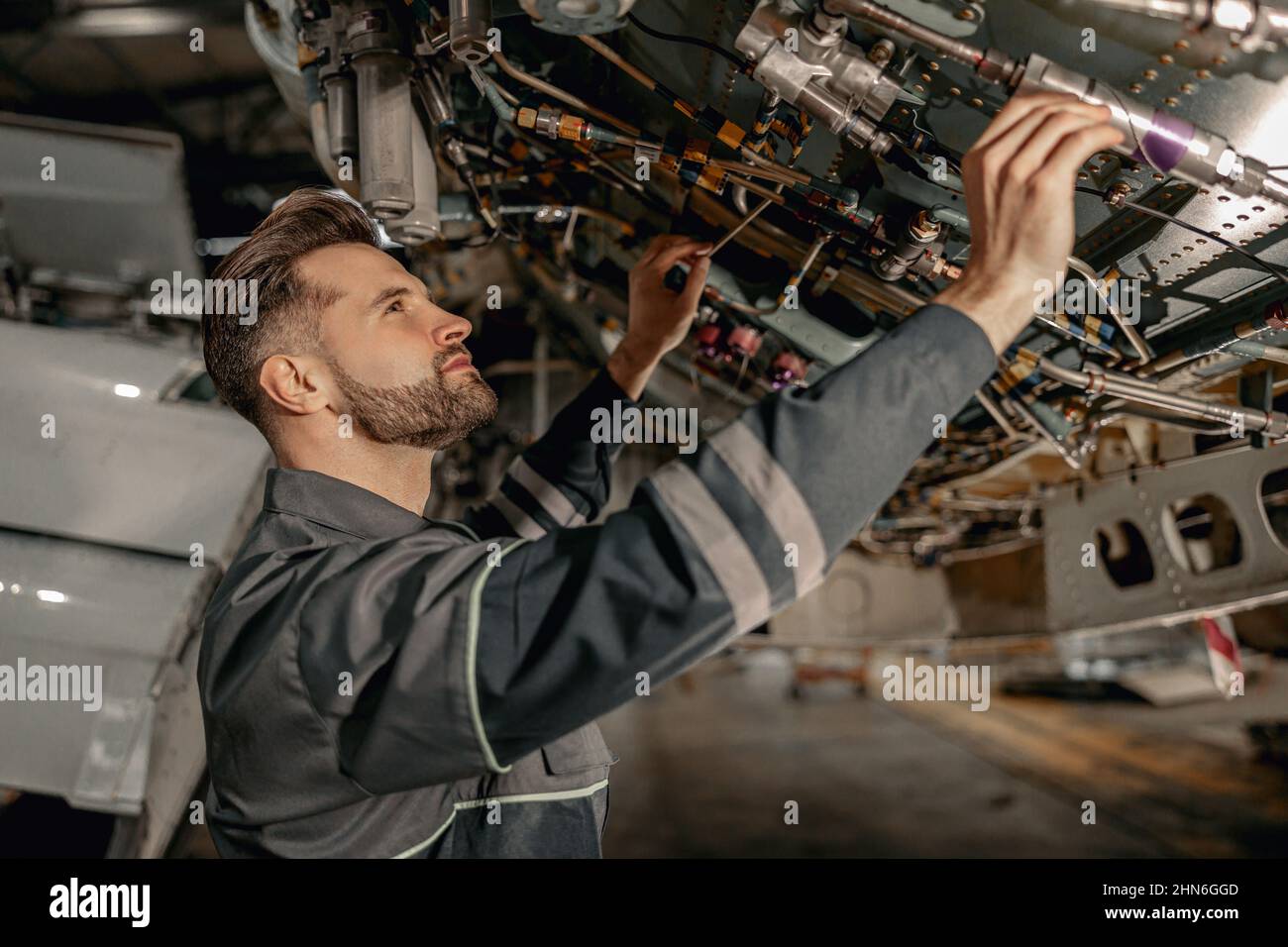 Male aviation mechanic inspecting aircraft components in hangar Stock Photo - Alamy