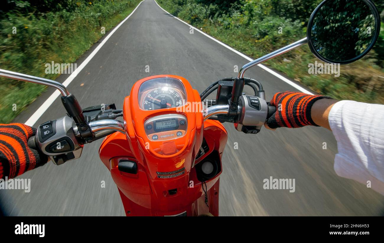 Scooter road trip. POV view, first person. Men on red motorbike in ...