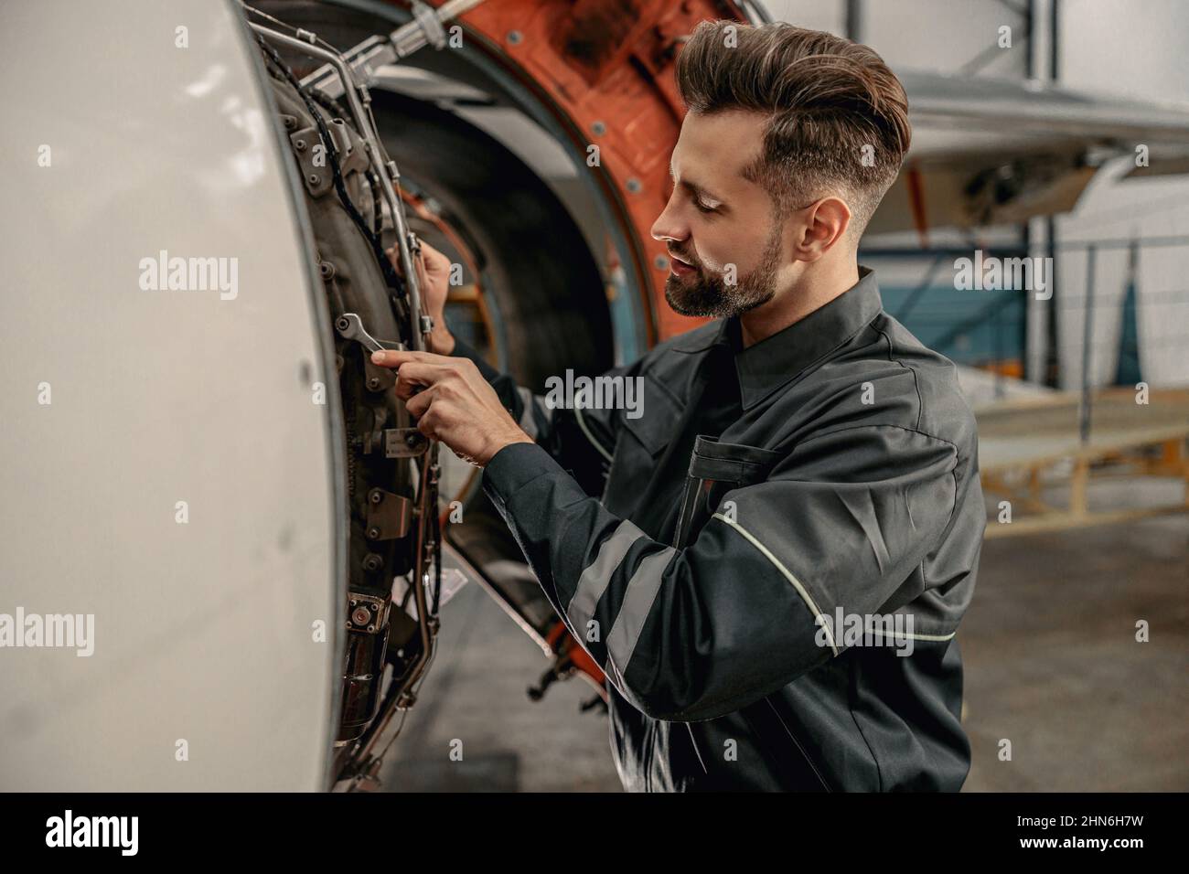 Male aviation mechanic repairing aircraft in hangar Stock Photo - Alamy