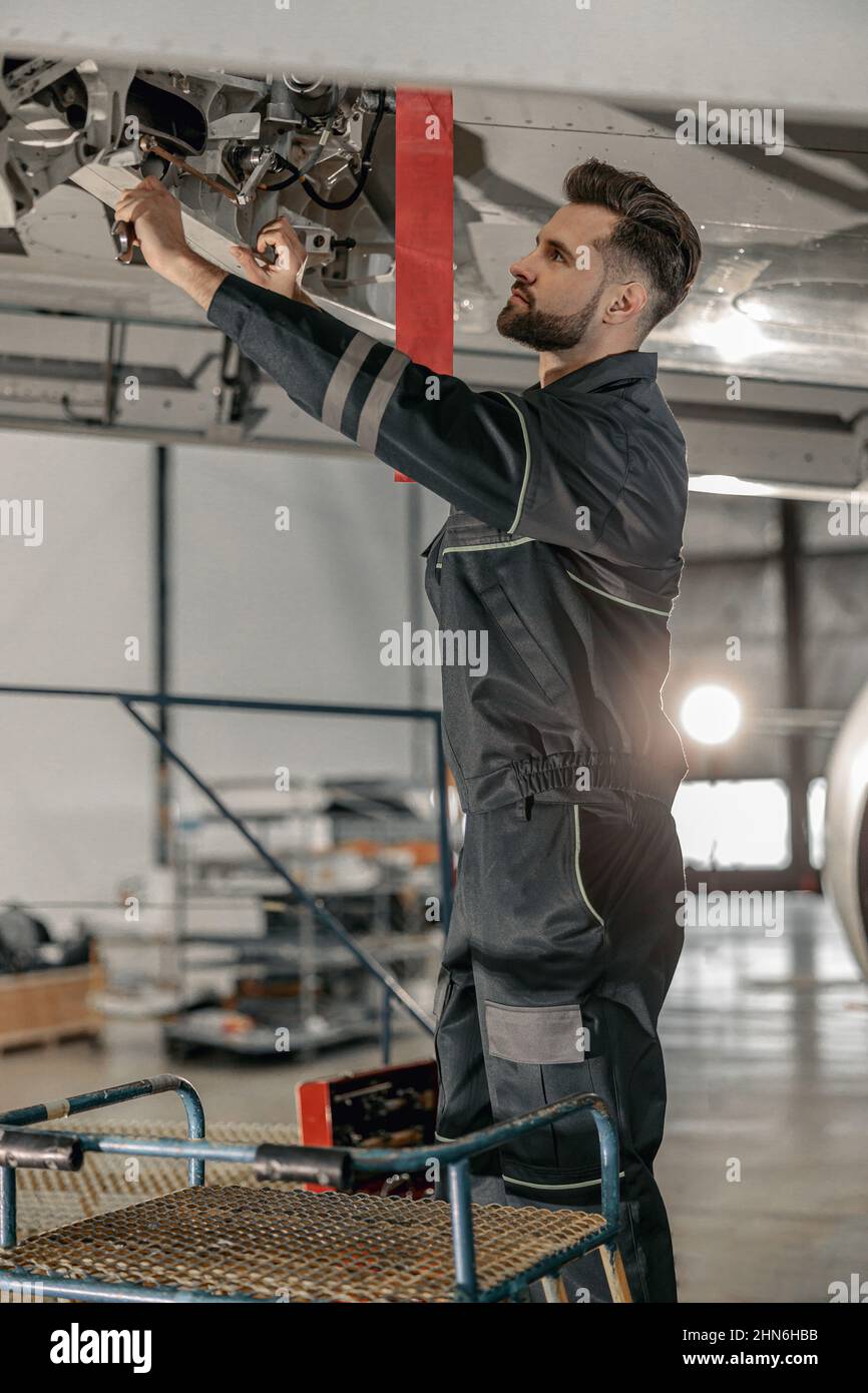 Male aviation mechanic repairing aircraft at repair station Stock Photo - Alamy