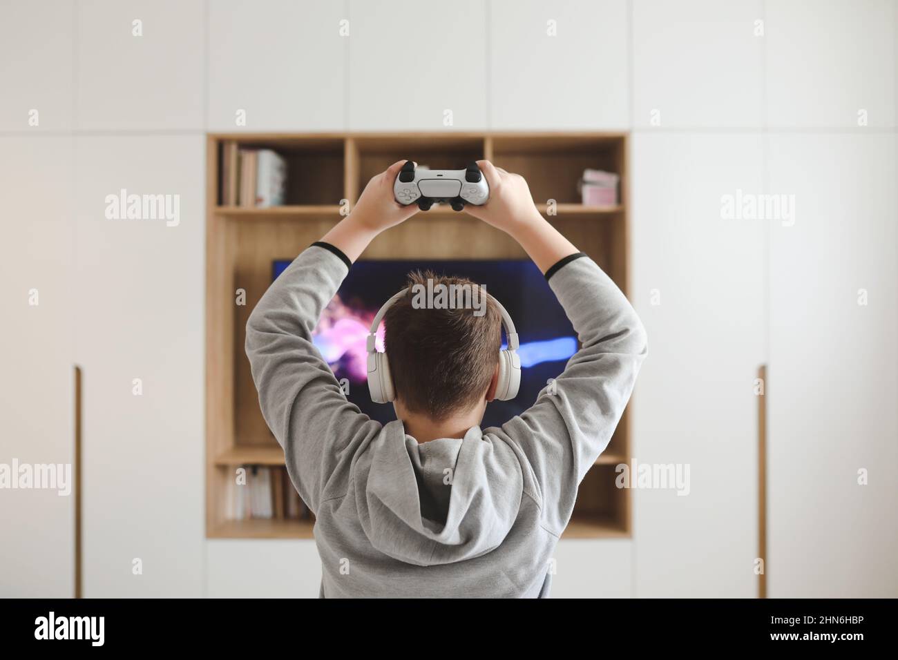 Boy in headphones watching television, teenager boy playing video game ...