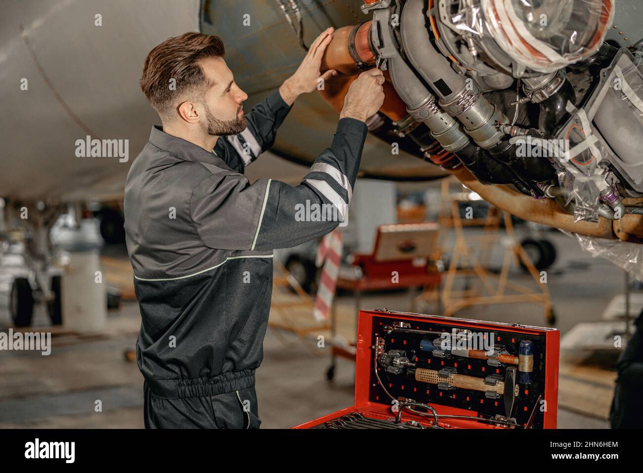 Male airline mechanic repairing aircraft in hangar Stock Photo - Alamy