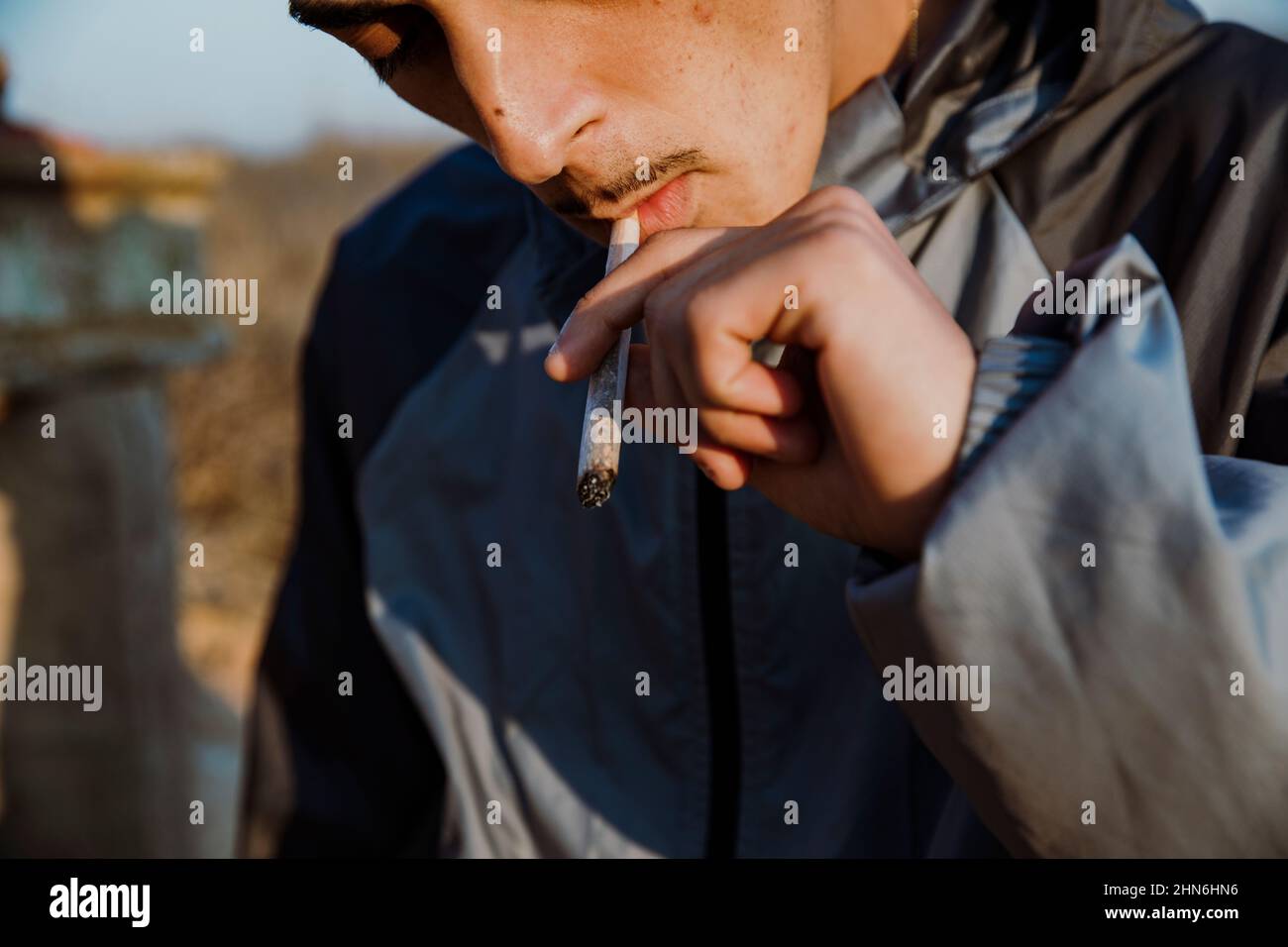 Close-up of young man smoking a marijuana joint outdoors Stock Photo ...