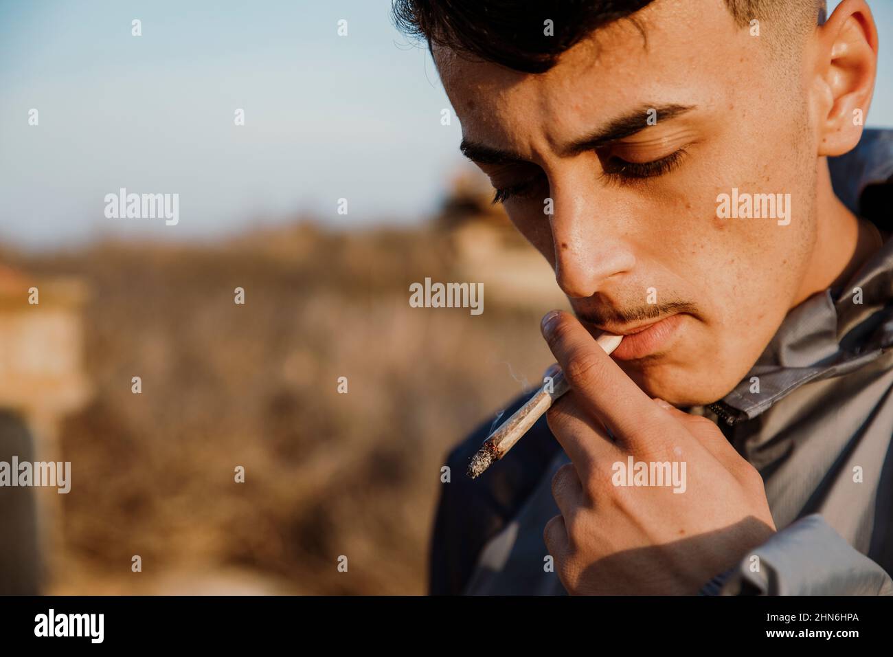 Close-up of young man smoking a marijuana joint outdoors Stock Photo ...
