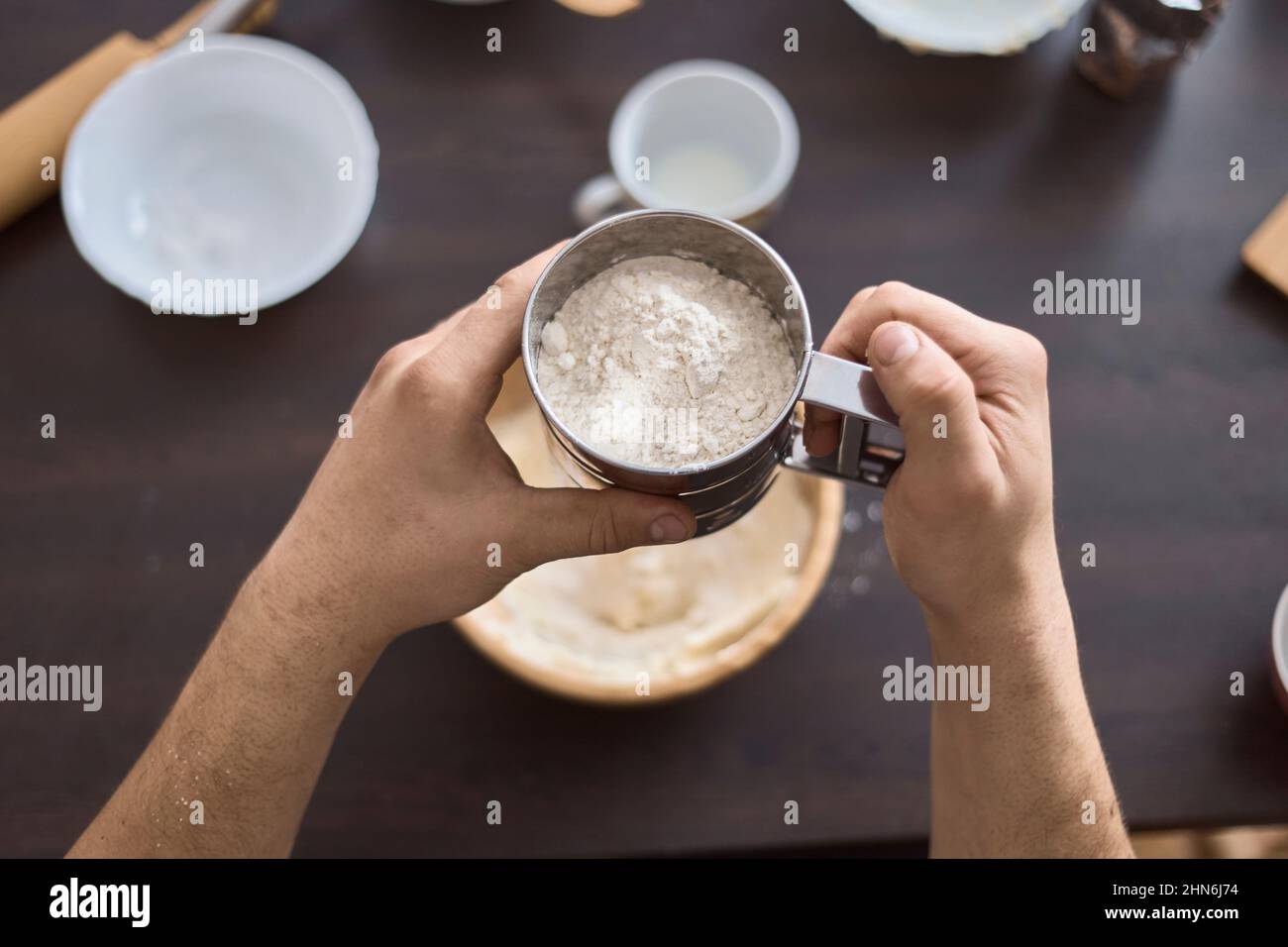 Top view of a man's hands with a sieve in his hands Stock Photo - Alamy