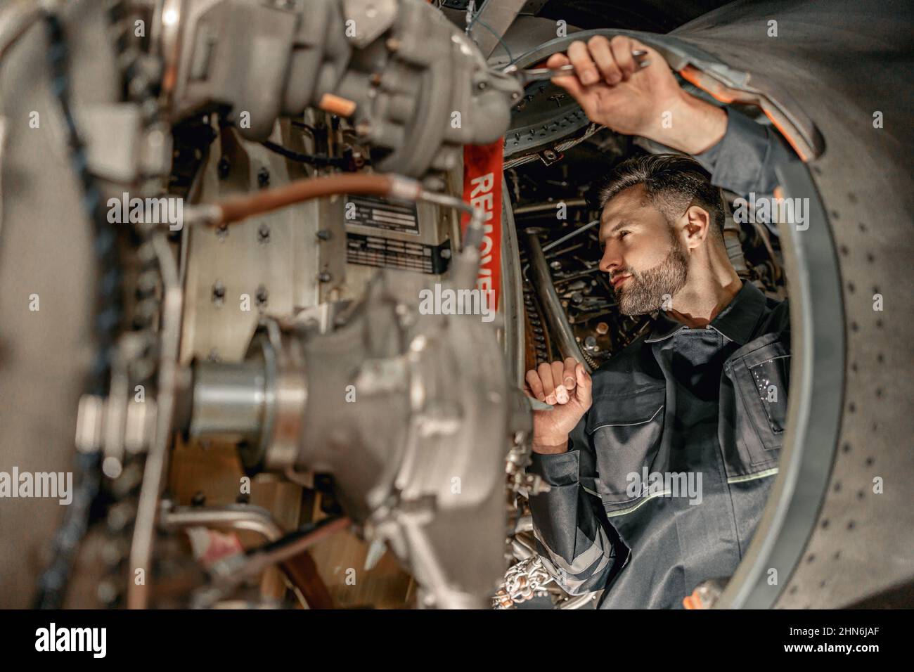 Bearded man mechanic repairing aircraft in hangar Stock Photo - Alamy