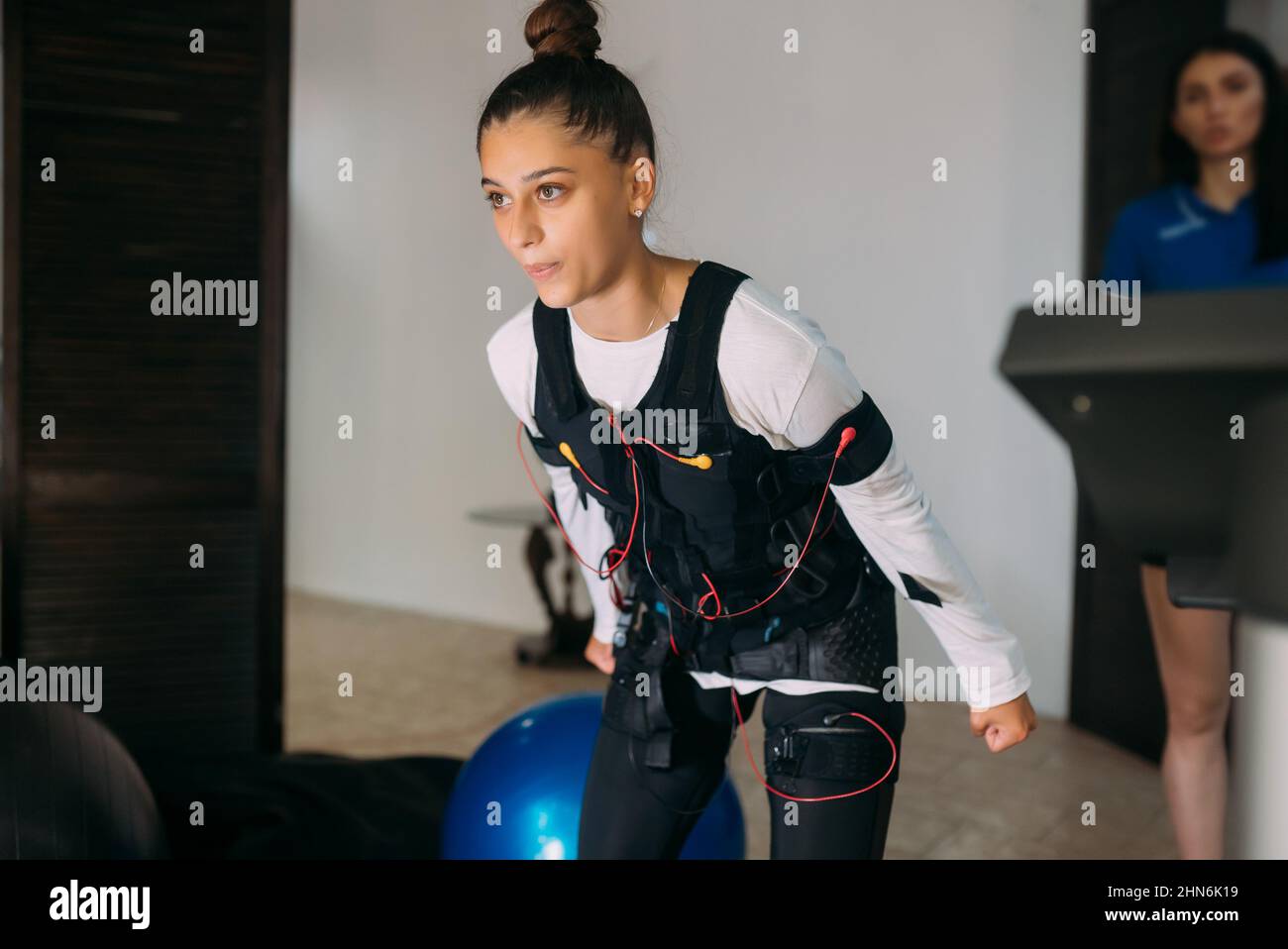 EMS training. Girl doing exercises in a suit with cables Stock Photo ...