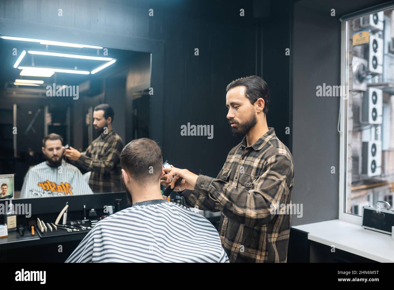 Master in barbershop makes men's haircutting with hair clipper Stock ...