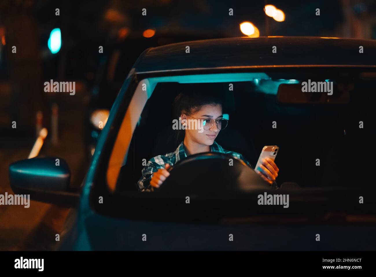 Lost female driver using mobile phone while driving at night Stock ...