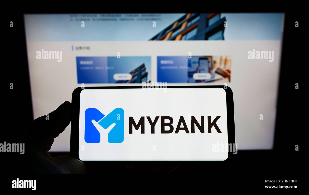 Person holding cellphone with logo of Chinese financial services ...