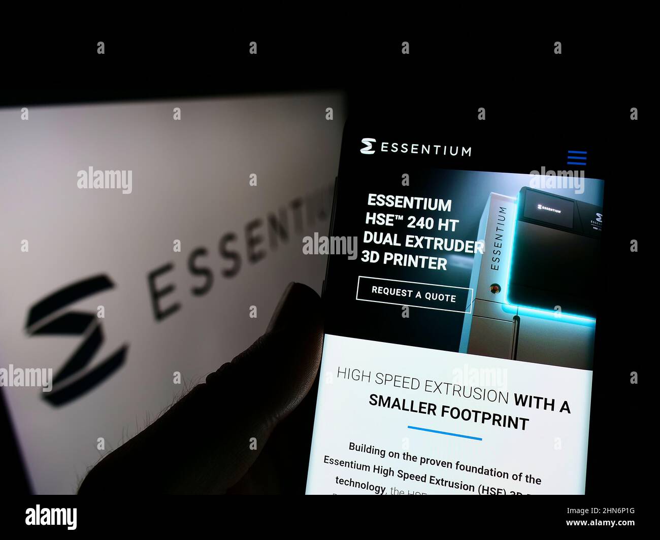 Person holding cellphone with webpage of US 3D printing company ...