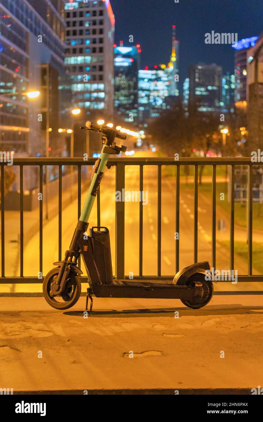 e-scooter on bridge in front of city skyline at night in frankfurt main ...