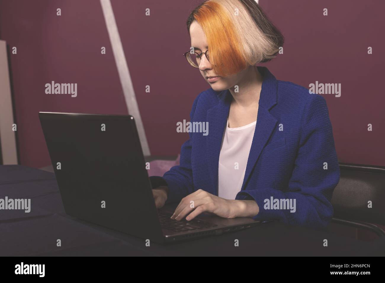 Secretary girl in blue business suit and multi-colored hair sits at ...
