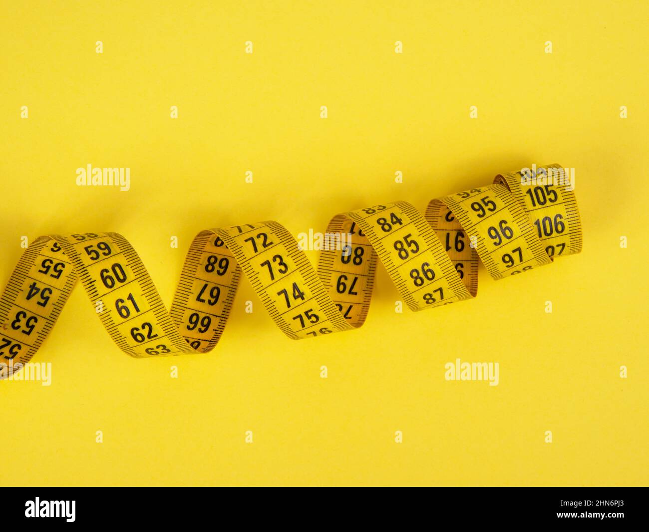 Yellow tape measure centimetric with copy space on yellow background ...