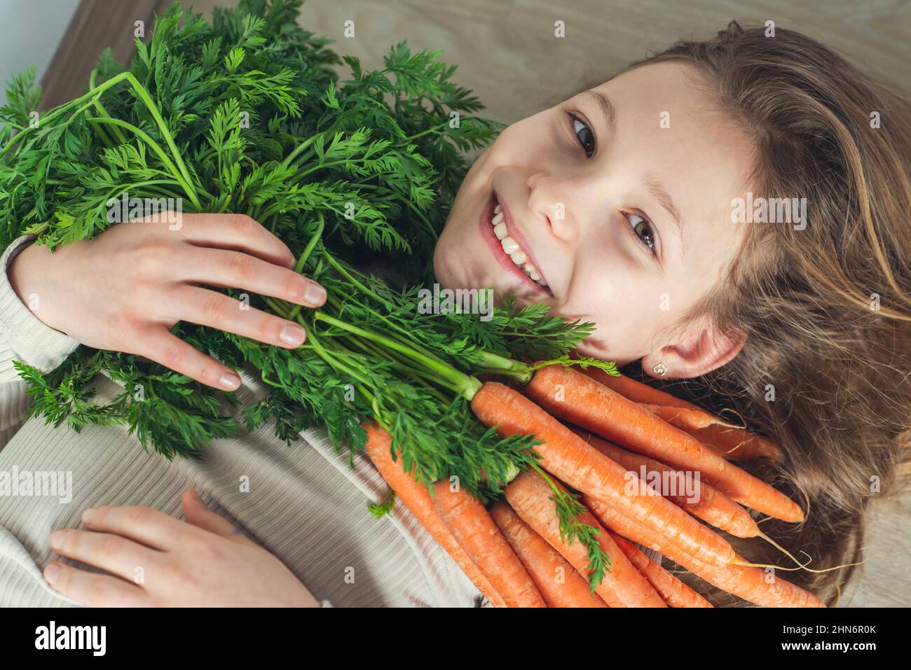 Smiling happy teen girl lying on the floor with a bunch of fresh orange ...