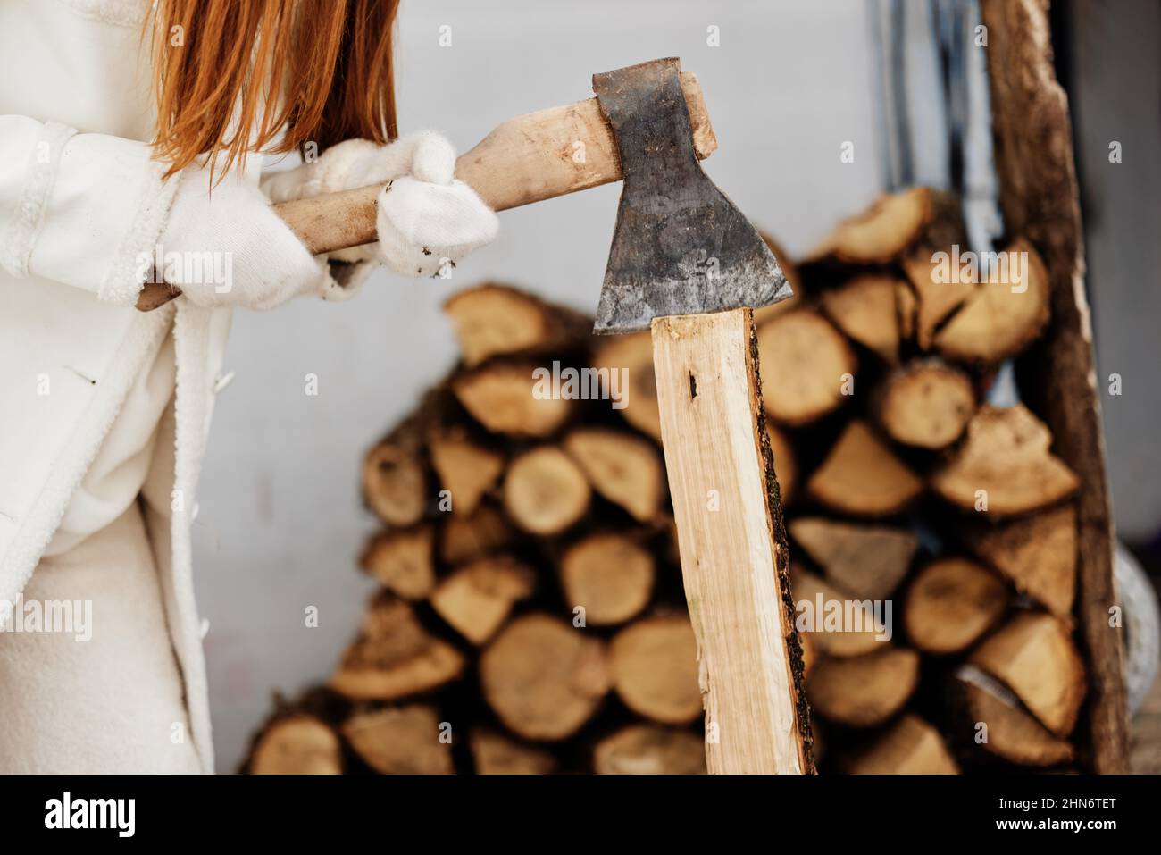 portrait of a woman sitting next to firewood heating winter nature ...