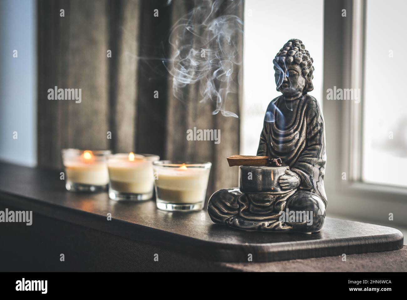 Candlestick in the shape of a buddha, smoldering Palo Santo and burning ...