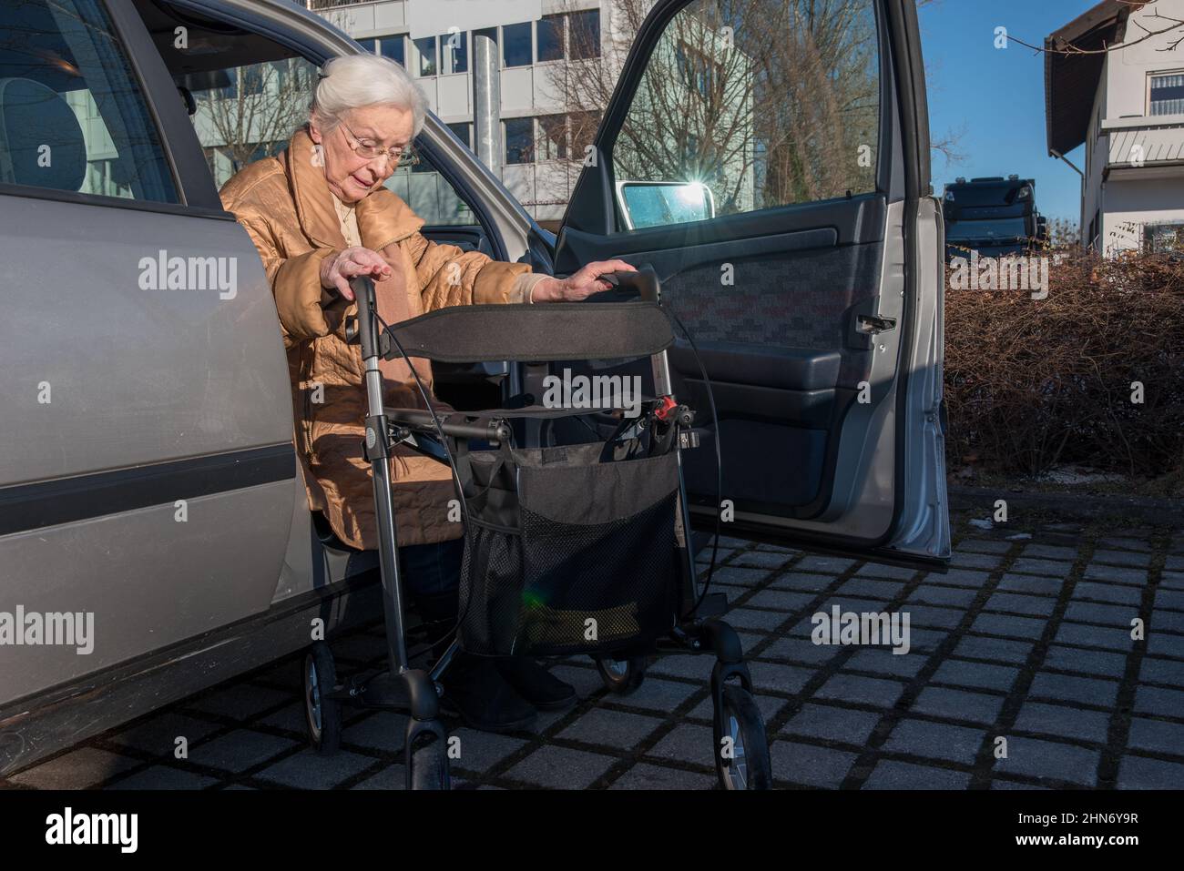 Senior woman with helping rollator getting out of car Stock Photo - Alamy