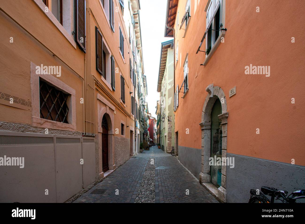 Long narrow old street with a beautiful stone path and antique windows ...
