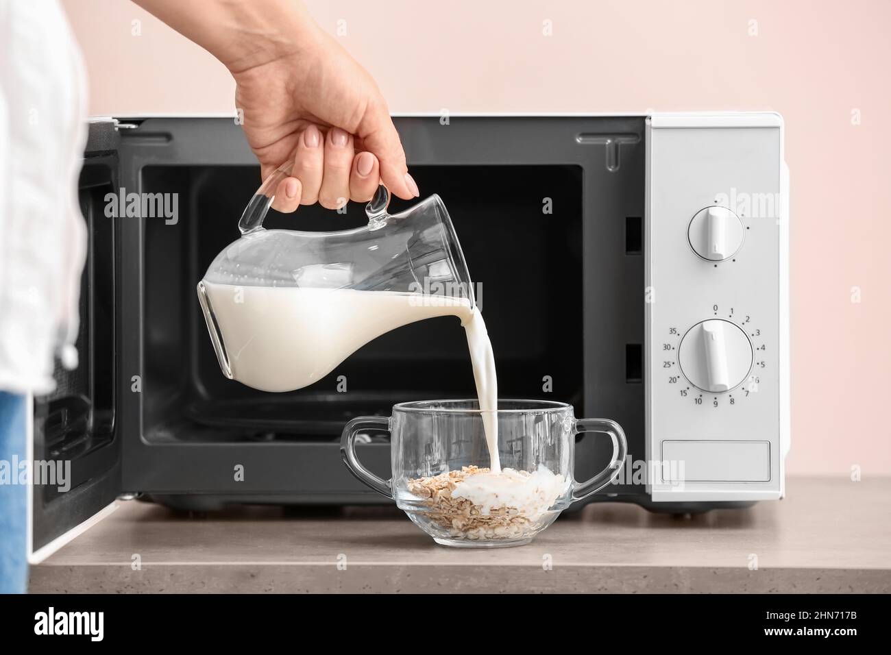 Woman adding milk oatmeal hi-res stock photography and images - Alamy