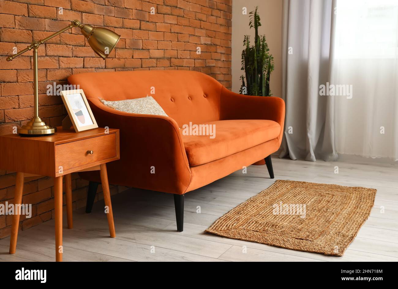 Interior of stylish living room with red sofa, table and golden lamp ...