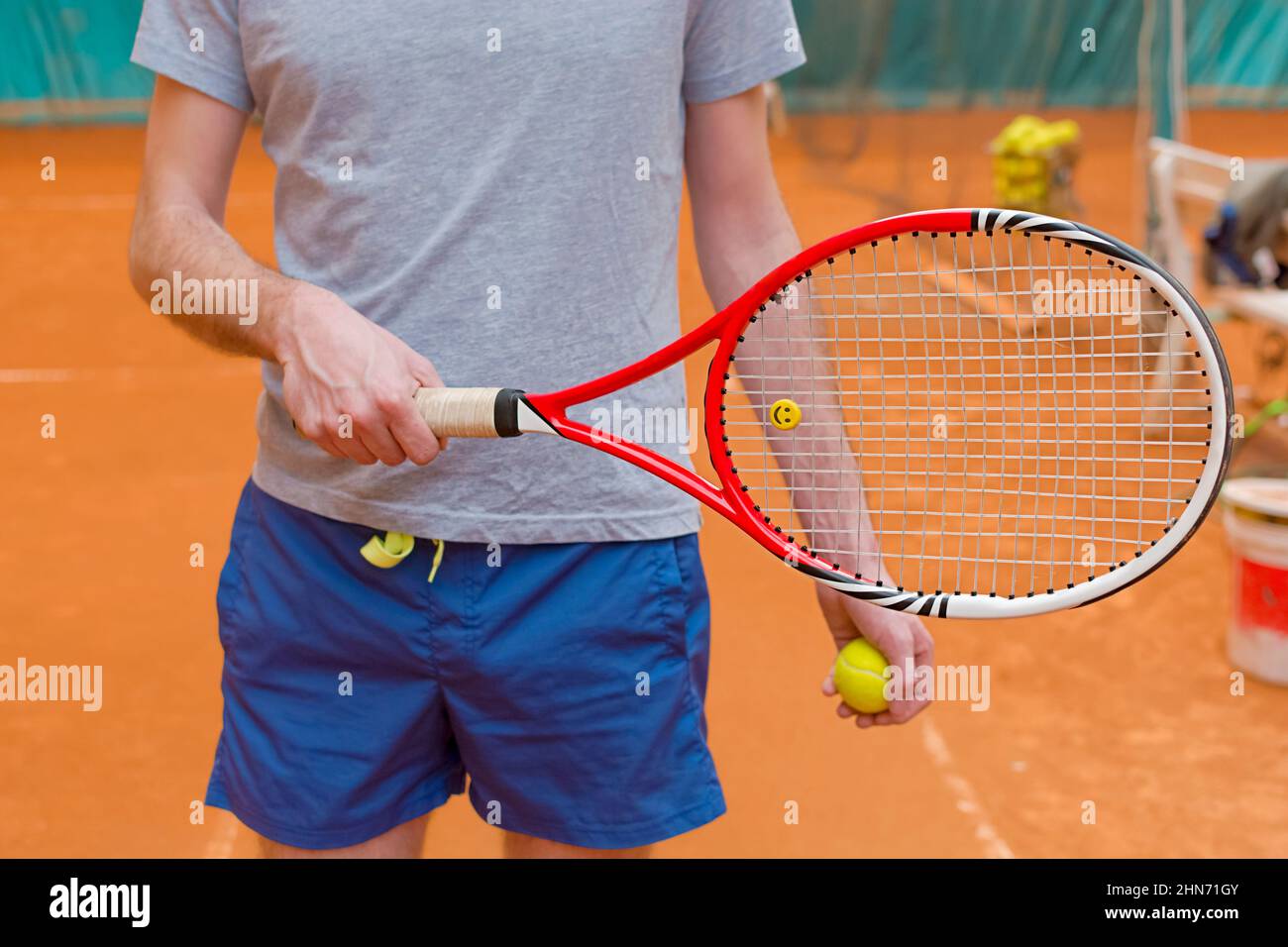 Tennis player holding racket and yellow ball on the tennis court Stock ...