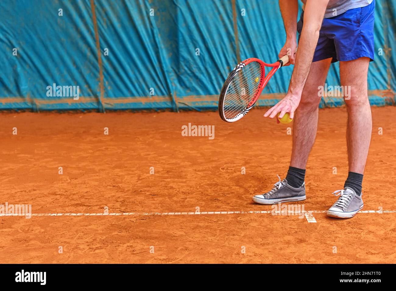 Tennis player holding racket and yellow ball ready to serve and play ...