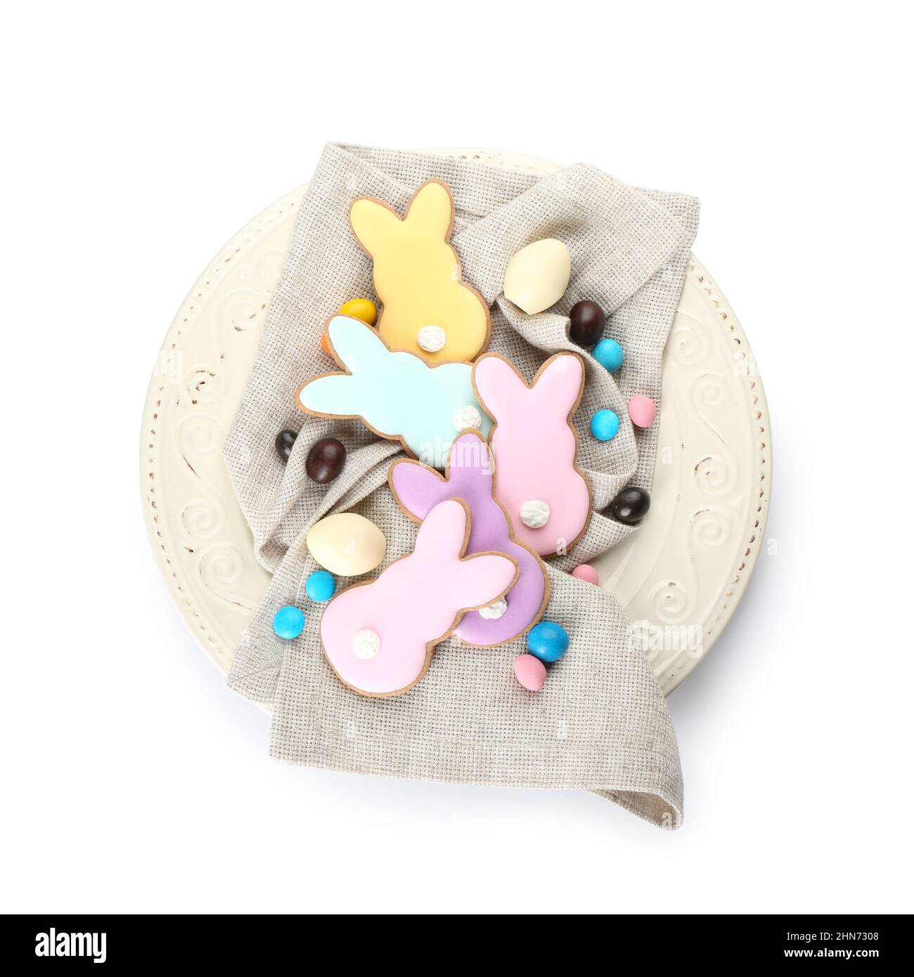 Plate with delicious Easter cookies in shape of bunny and candies on ...