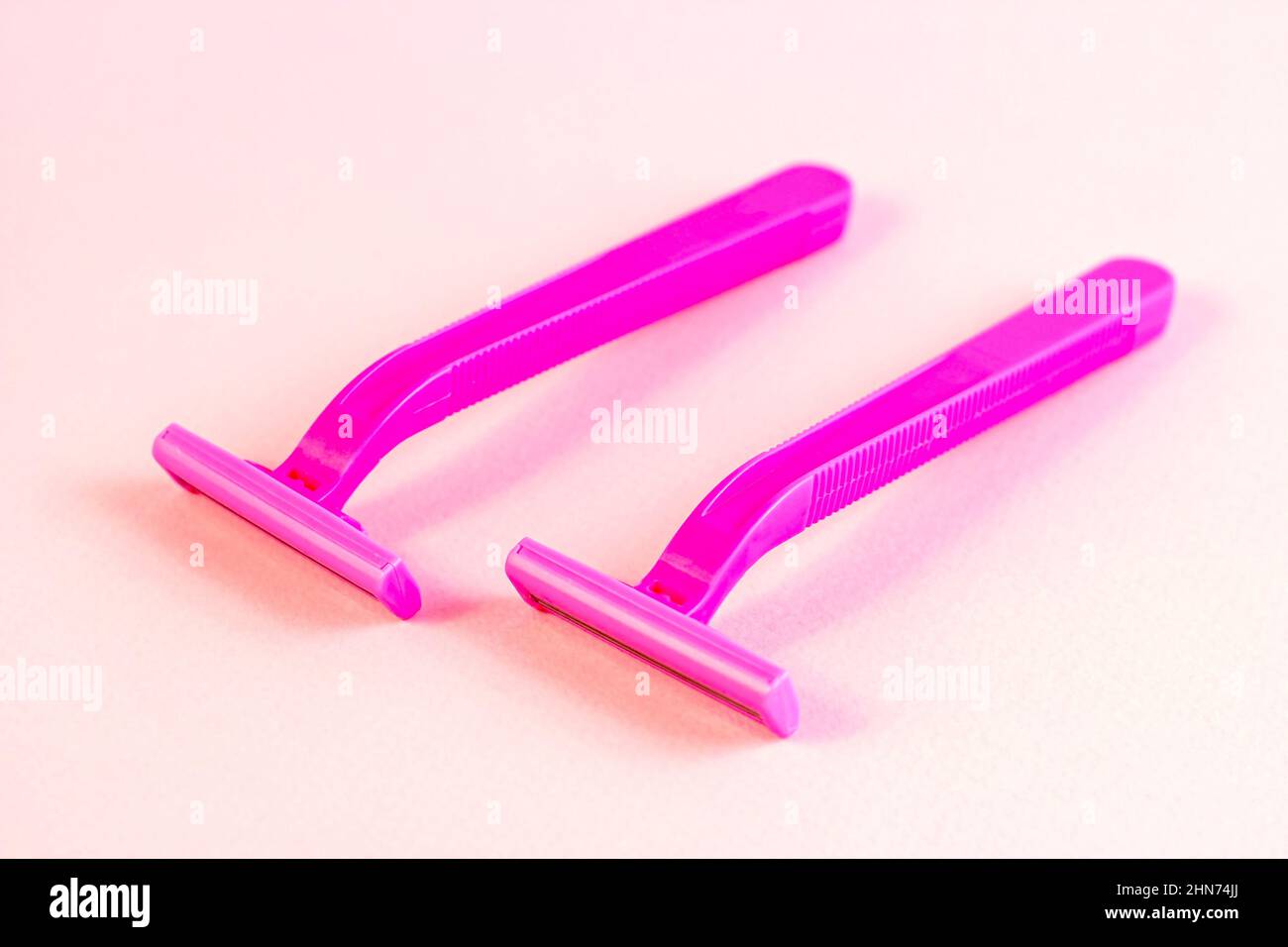 Pink disposable woman razors on light pastel background. Hair removing ...
