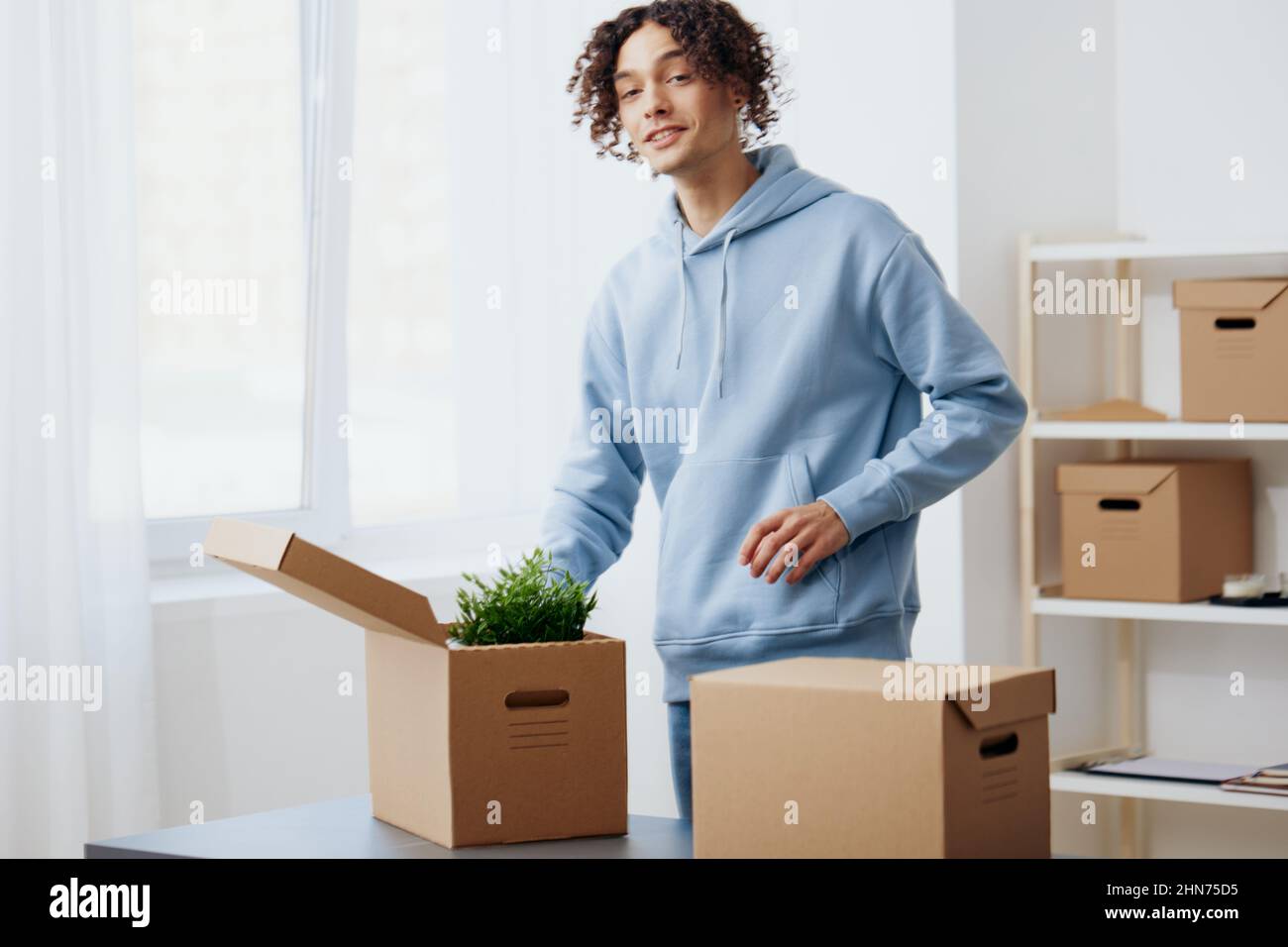 portrait of a man unpacking things from boxes in the room sorting ...